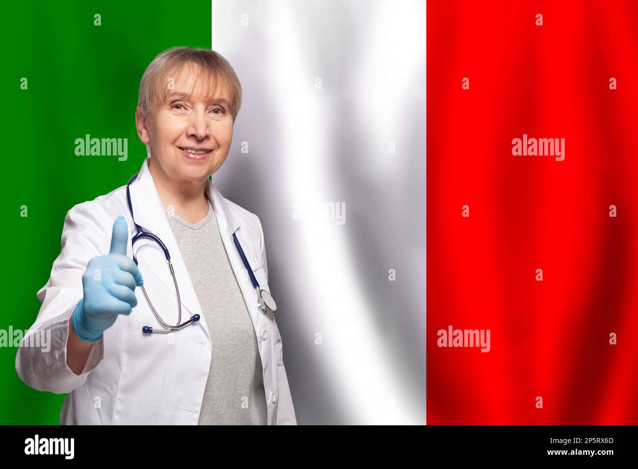 Italian smiling mature doctor woman holding stethoscope on flag of ...
