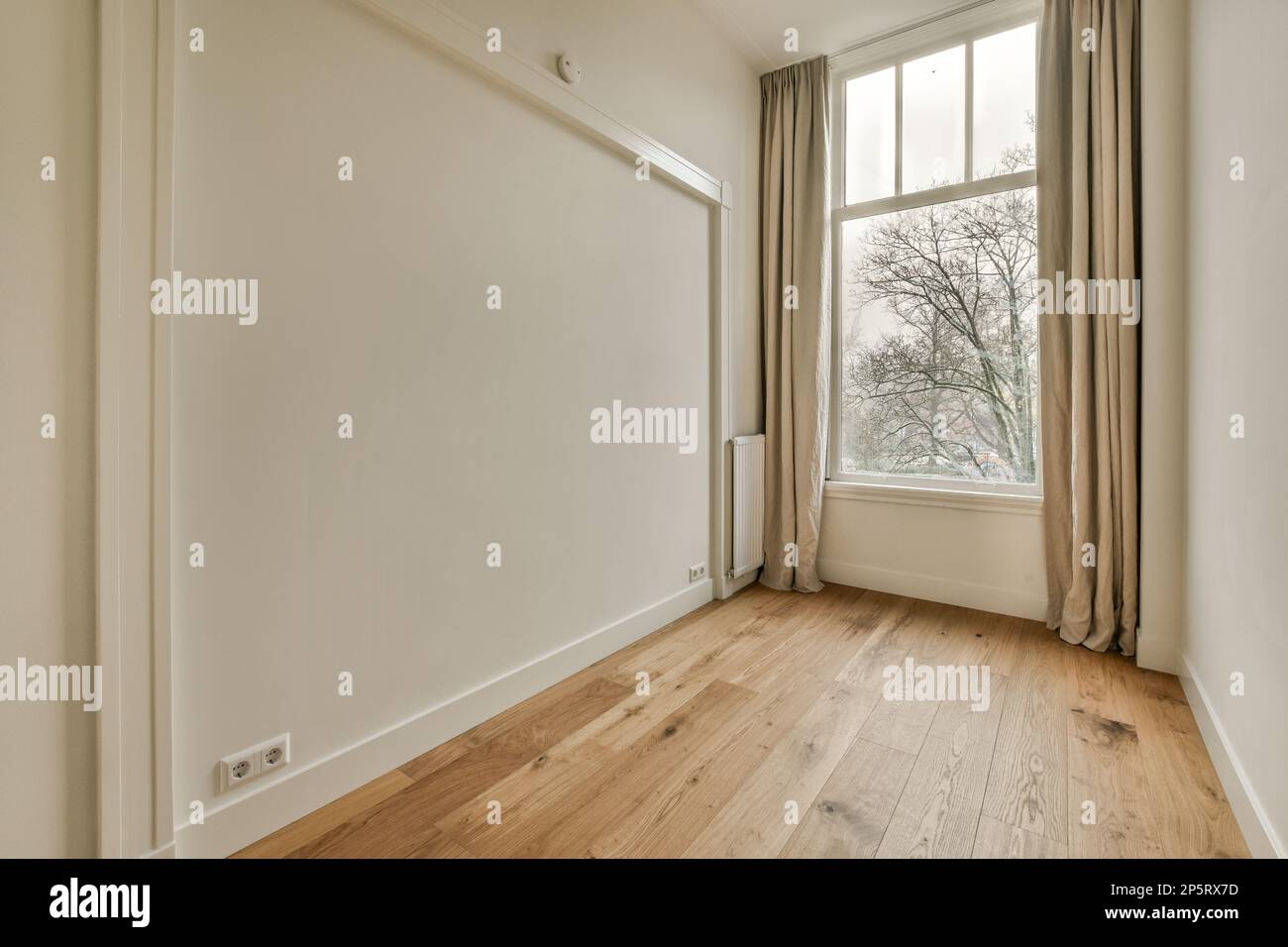 an empty room with wood floors and white walls, showing the natural ...