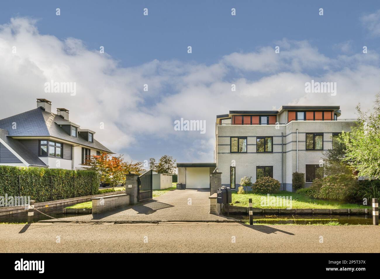 some houses in the day time with blue sky and white clouds above them ...