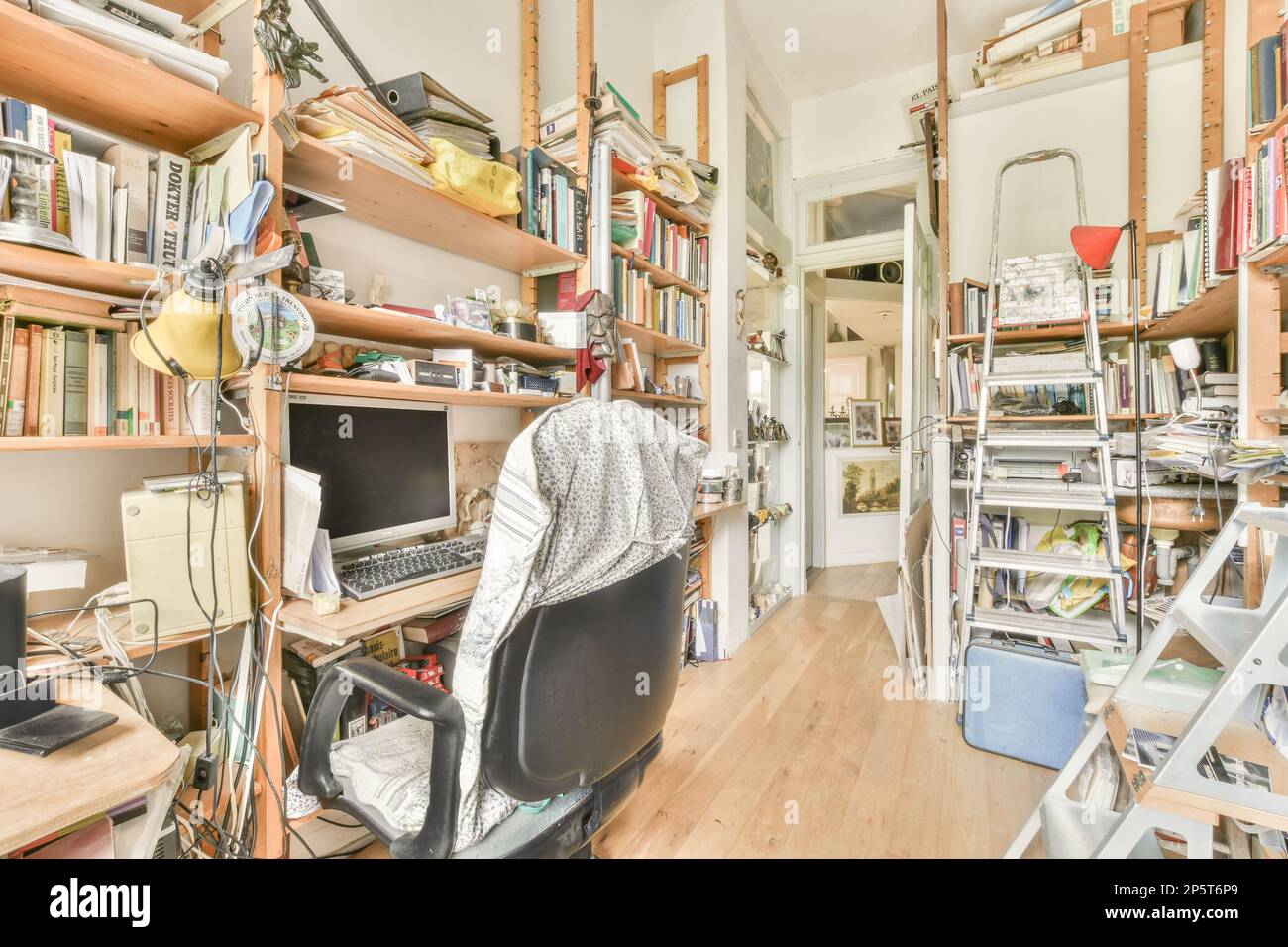 a messy home office with lots of clutters on the desk and shelves in ...