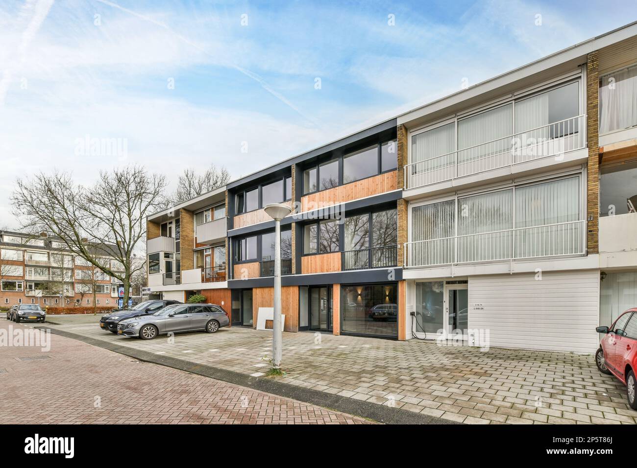 an apartment complex with cars parked on the side of the street in ...