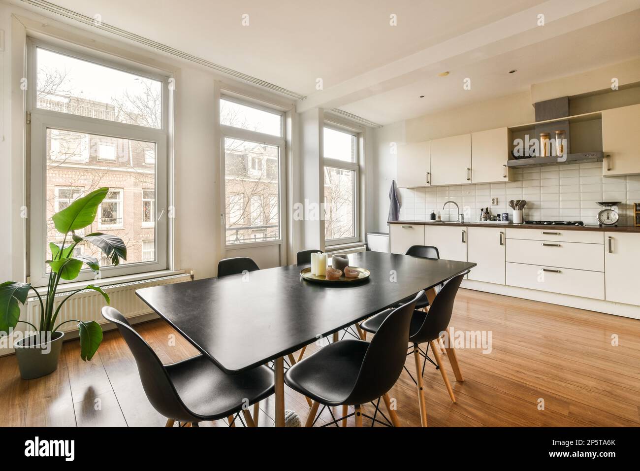a dining table and chairs in a room with large windows looking out onto ...