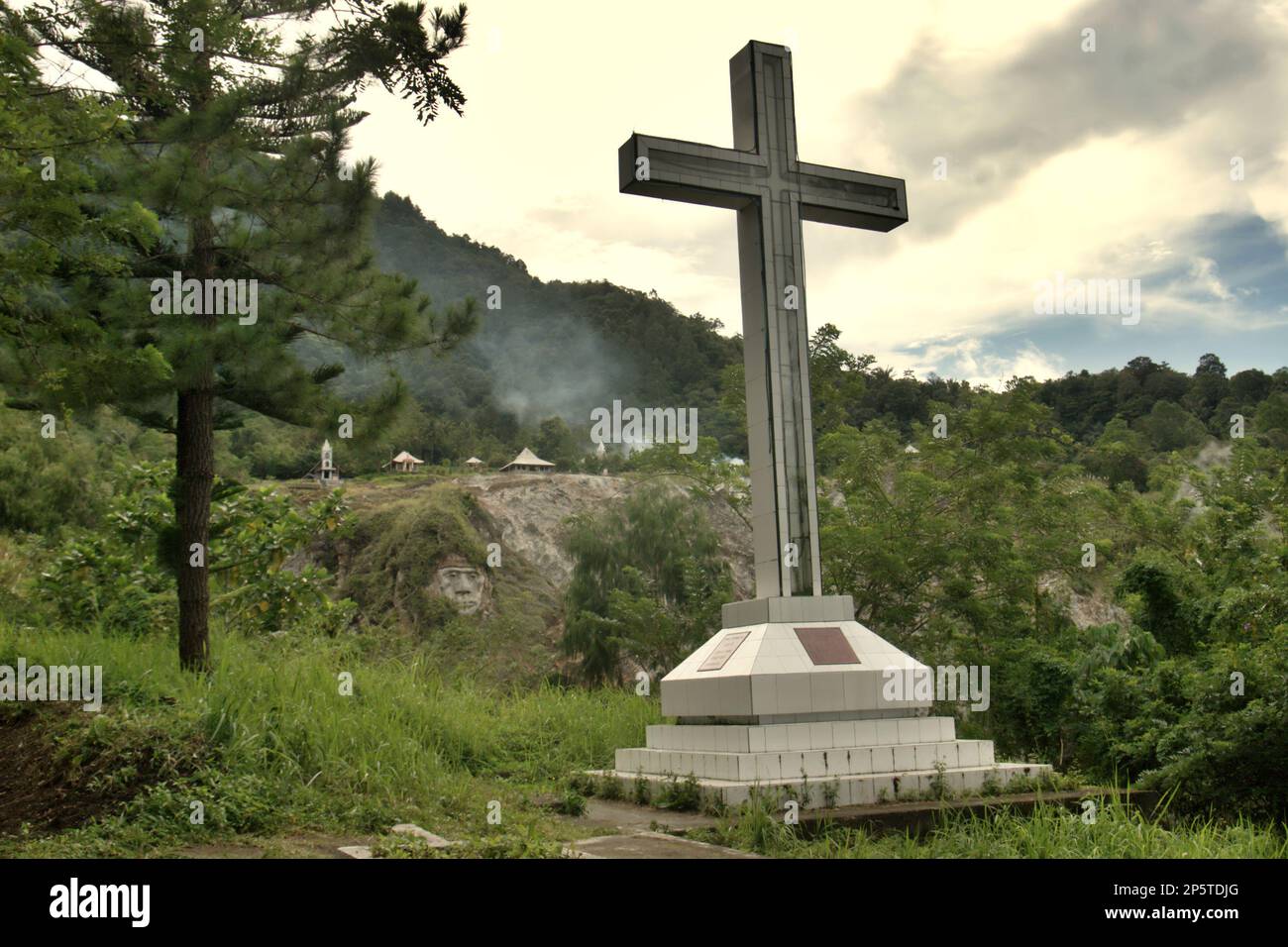 A Christian cross is seen on a ridge that leads to a flat ground of the ...
