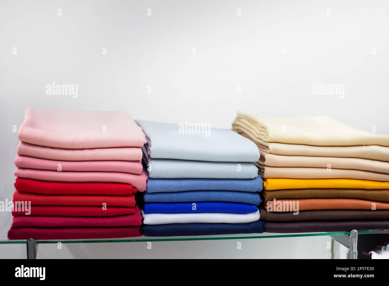 beautifully folded knitted multi-colored woolen things in piles ...