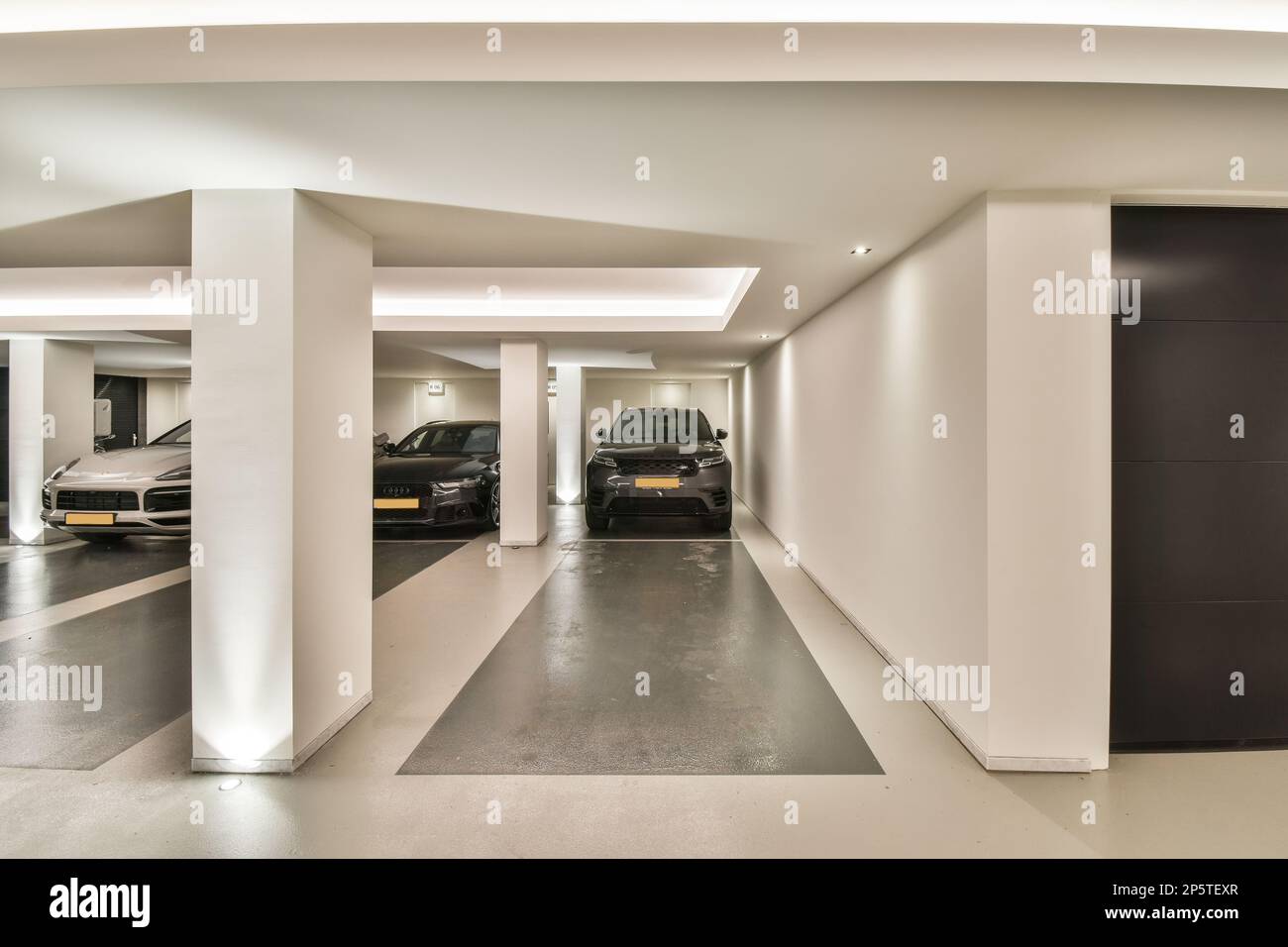 some cars parked in a car showroom with white walls and black flooring ...