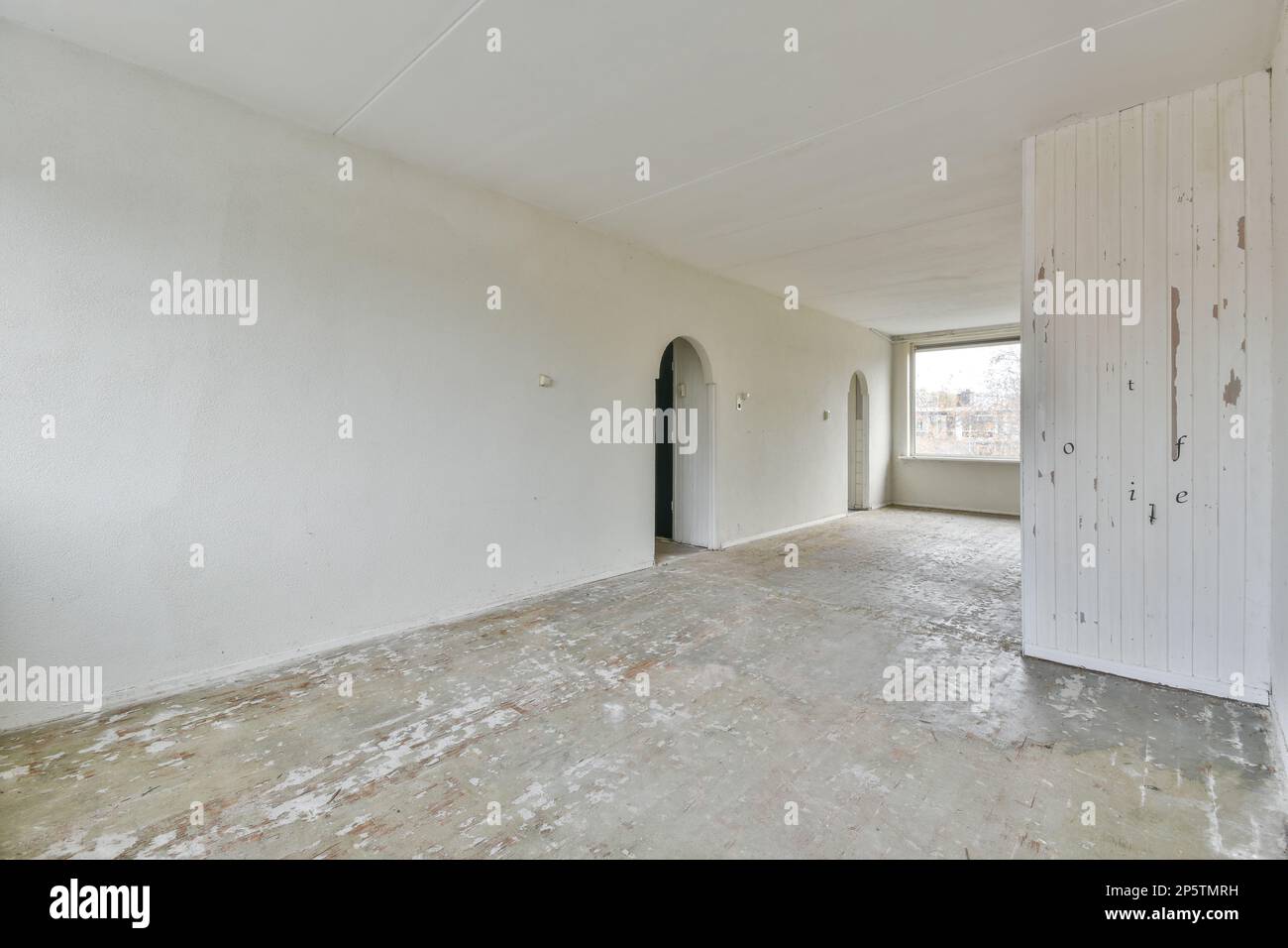 an empty room with white walls and wooden doors on either side of the ...