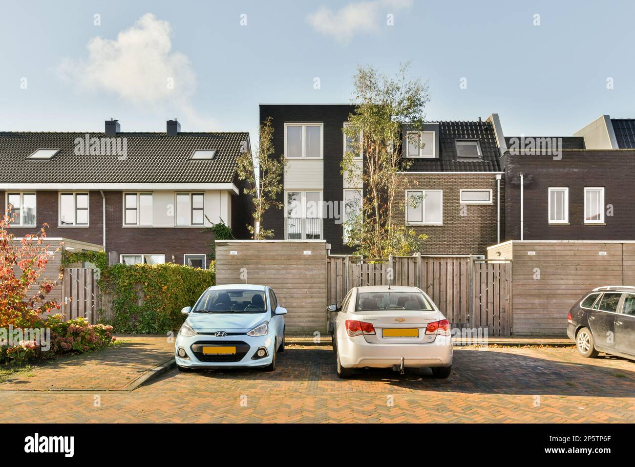 two cars parked next to each other car in front of a house on a sunny ...
