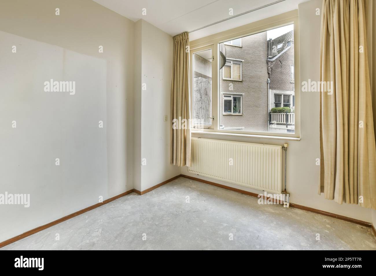 an empty room with a window and some curtains on the windowsilling it ...