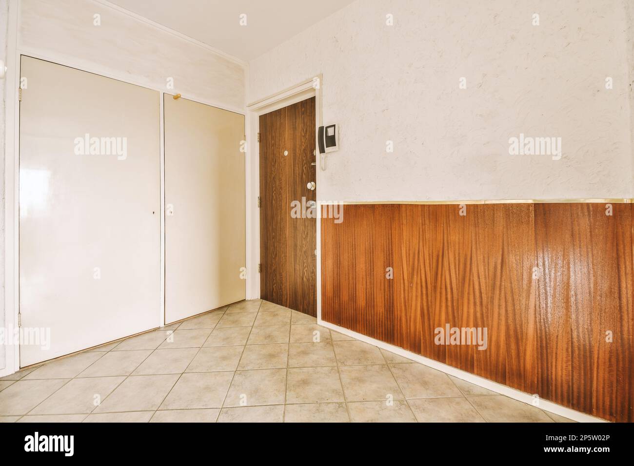 an empty room with wood paneling on the wall and tile floor in between ...
