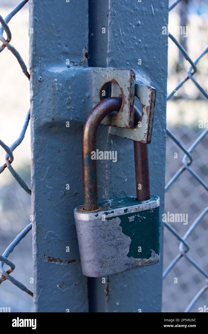 Large old padlock on a door in a metal fence Stock Photo - Alamy