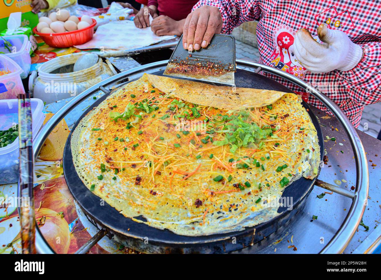 Pancake vendors at an open-air traditional market in Urumqi, Xinjiang ...