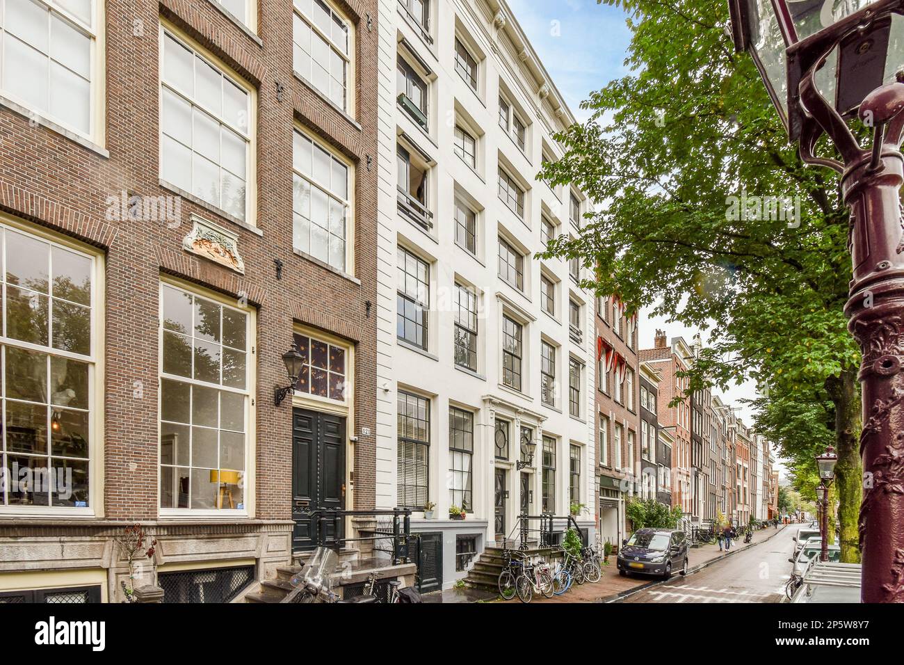 a city street with bikes parked on the side of the road and buildings ...