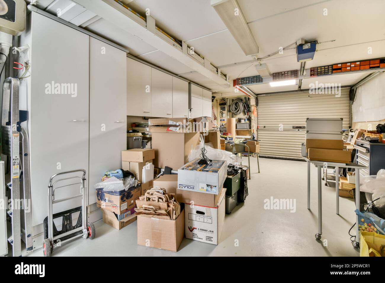 the inside of a garage with boxes, tools and other items on the floor ...