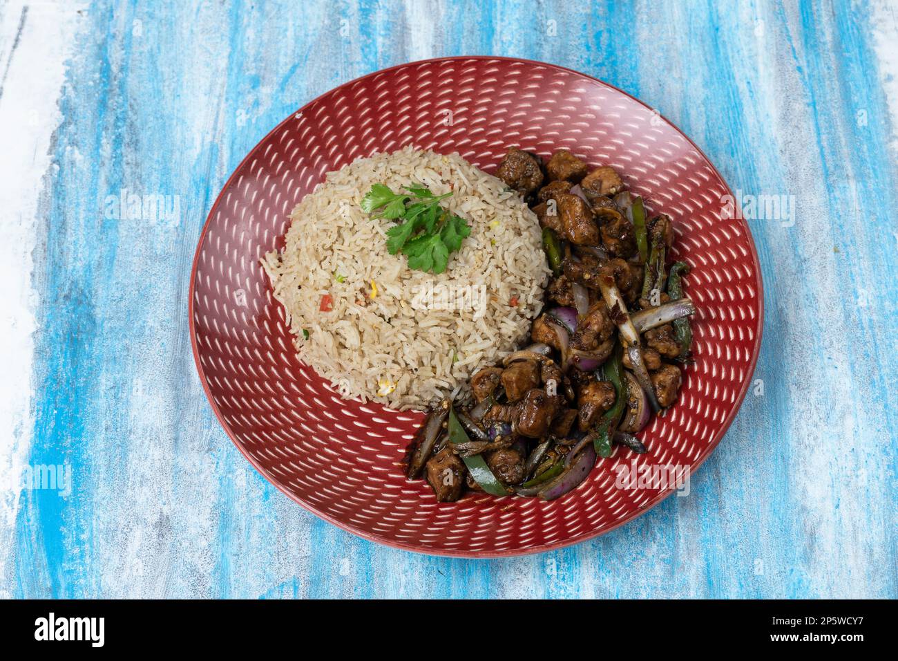 Chicken dry chili with a bowl of fried rice on textured background ...