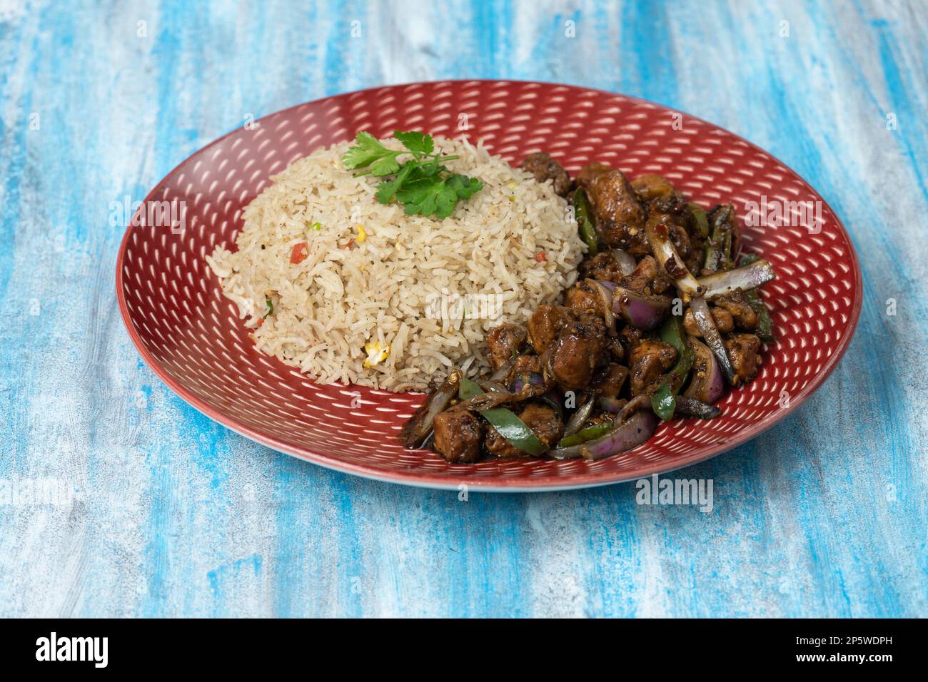 Chicken dry chili with a bowl of fried rice on textured background ...