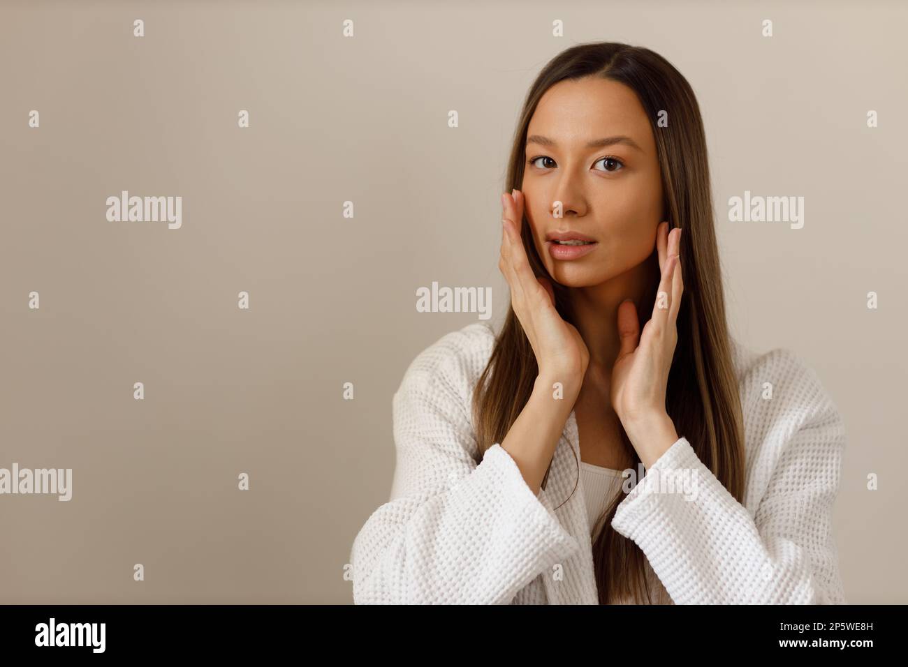 Young multiracial woman doing face building yoga and facial gymnastics ...