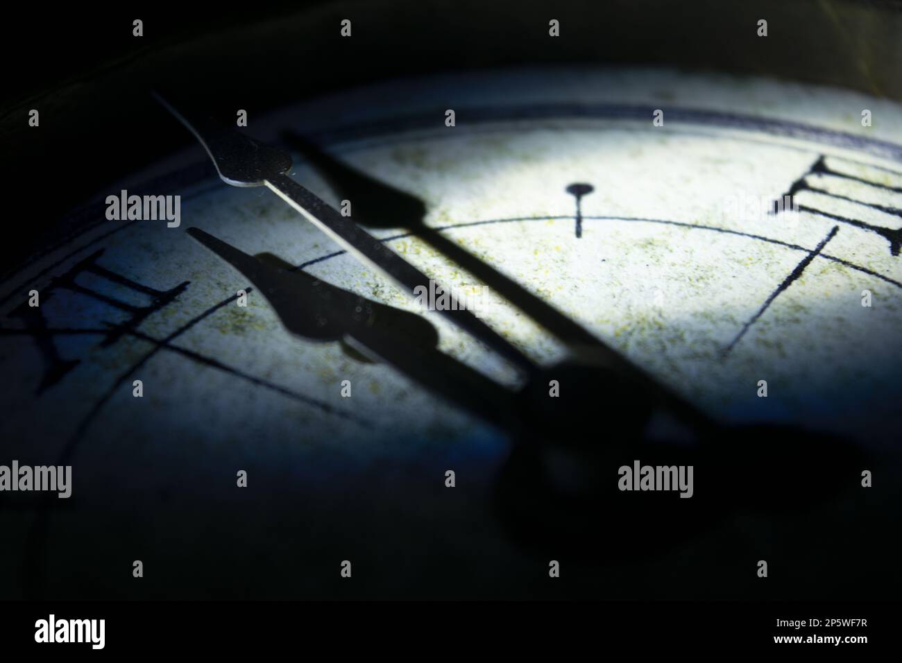 concept of time with the face of an old wall clock in directional light ...
