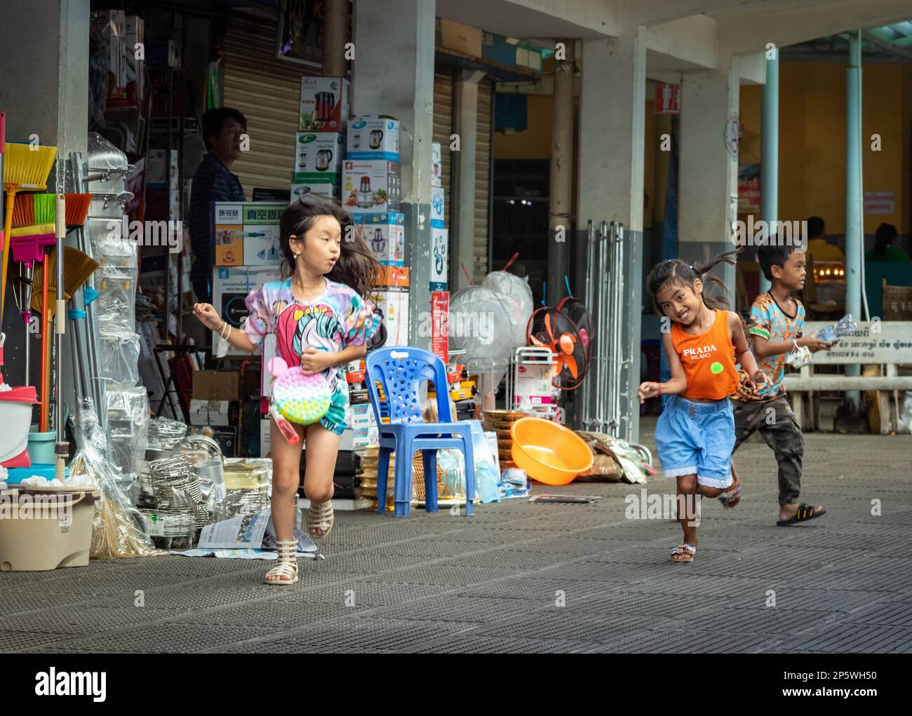 Two young girls and a young boy run and play at the Central Market in ...