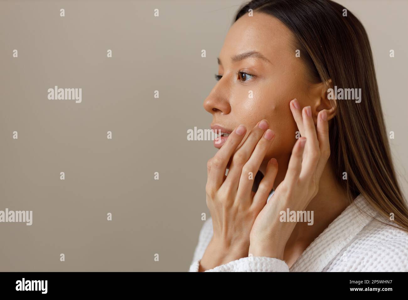 Acne Skin Of Young Woman In White Bathrobe Examines Pimples On Her Face