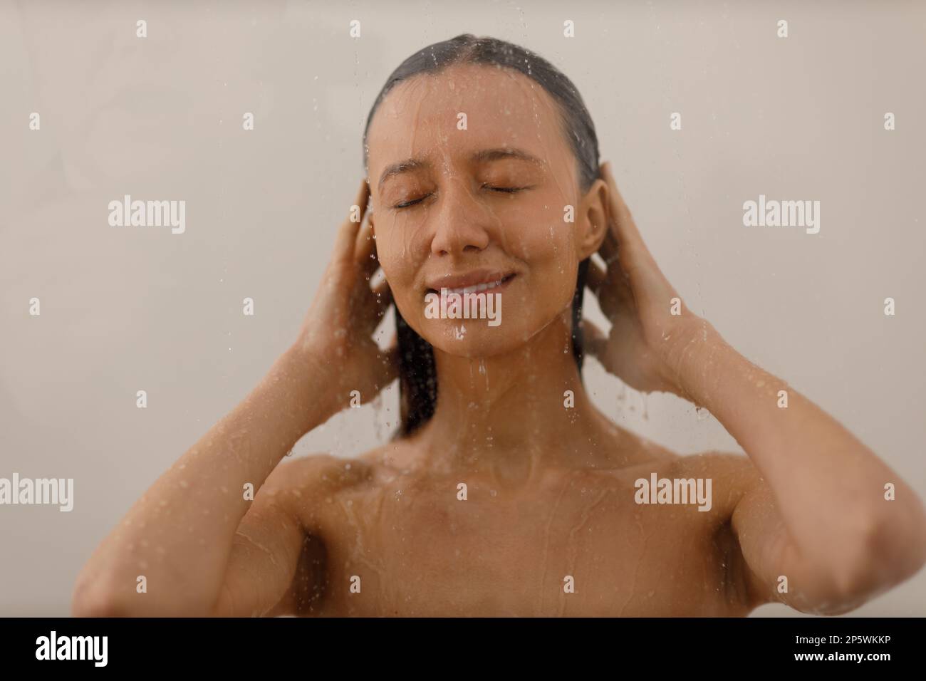 Young woman under trickles water in pleasure shower. Beautiful girl ... Young woman under trickles water in pleasure shower. Beautiful girl ...