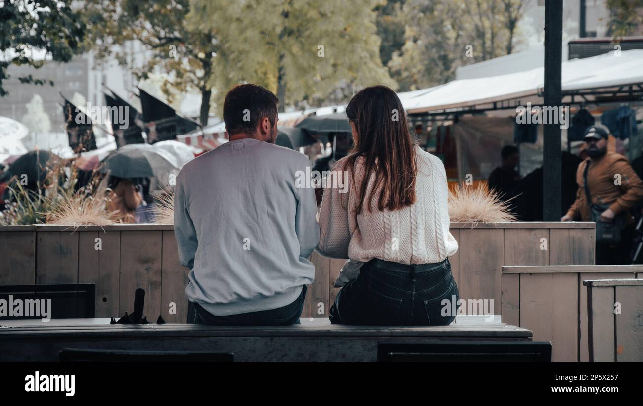Two people pause side by side, sharing a quiet moment amid the soft ...