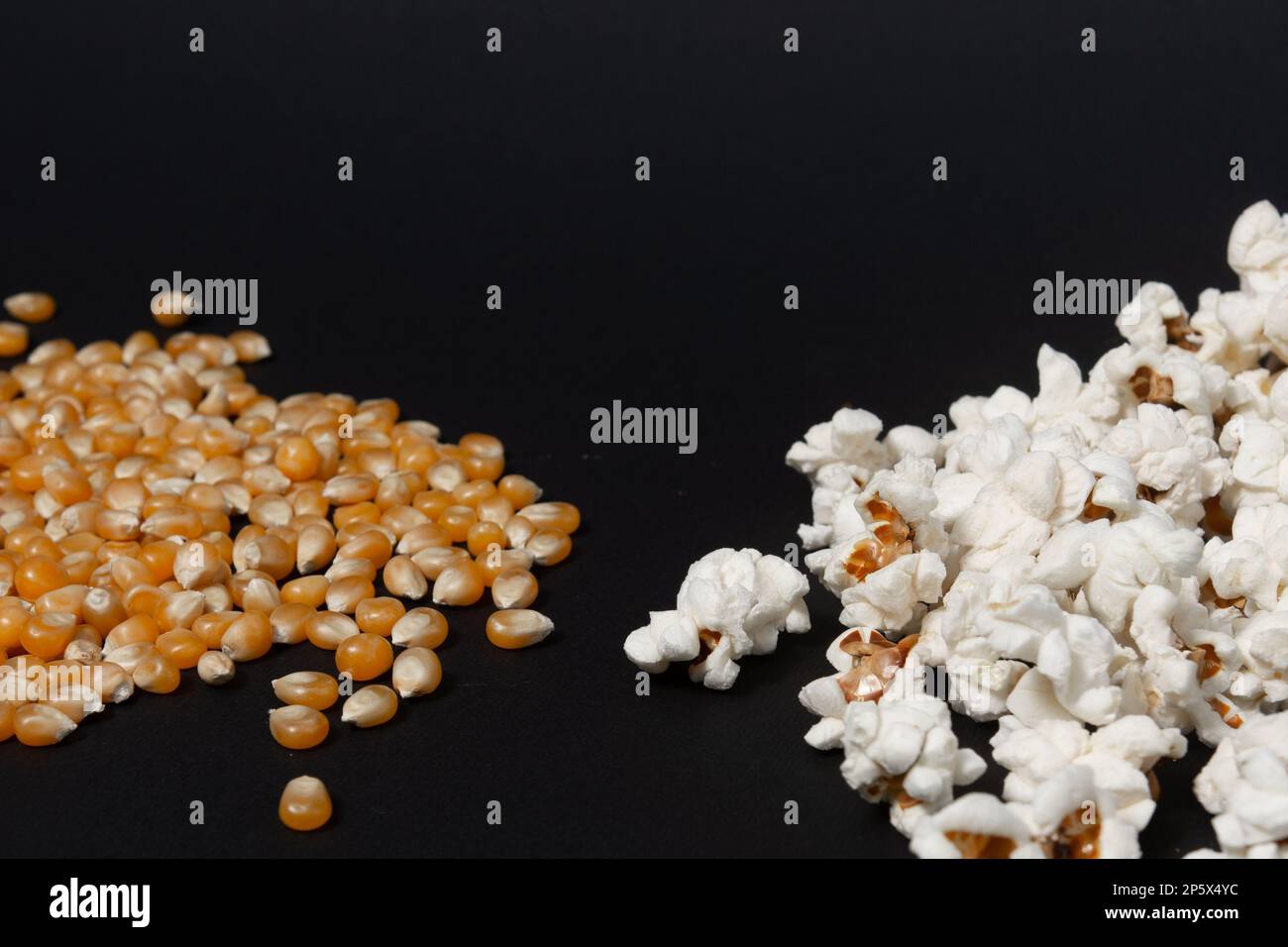 Two piles of popcorn, one pile of ready-made popcorn, another with corn ...