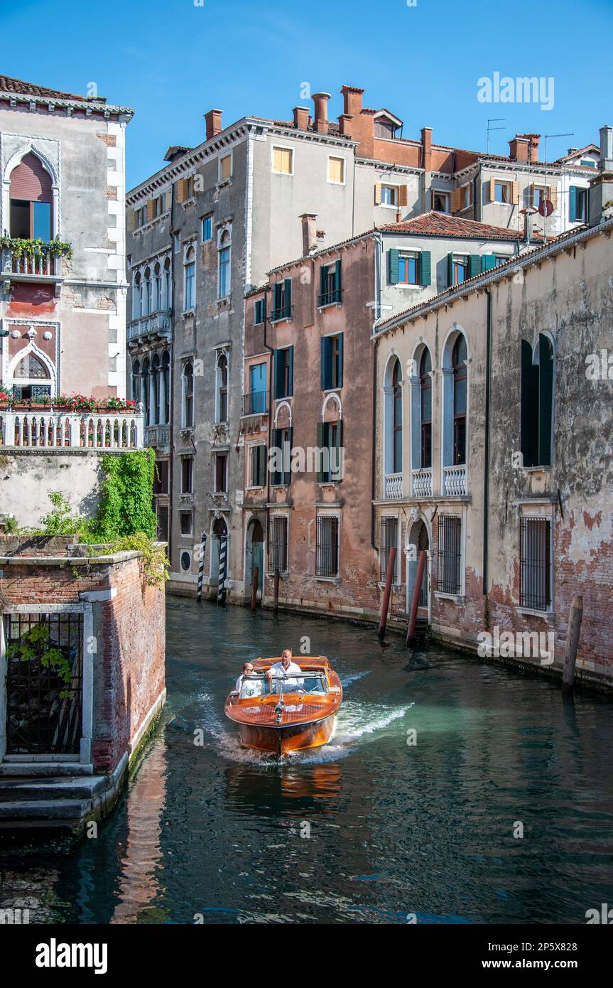 Gondolas and boats float on the magnificent Grand Canal in sunny Venice ...