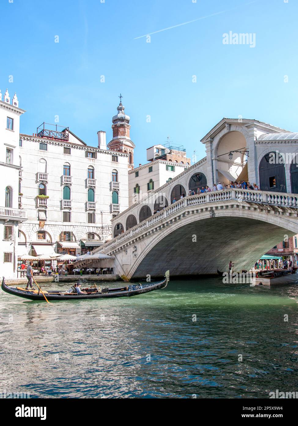 Gondolas and boats float on the magnificent Grand Canal in sunny Venice ...