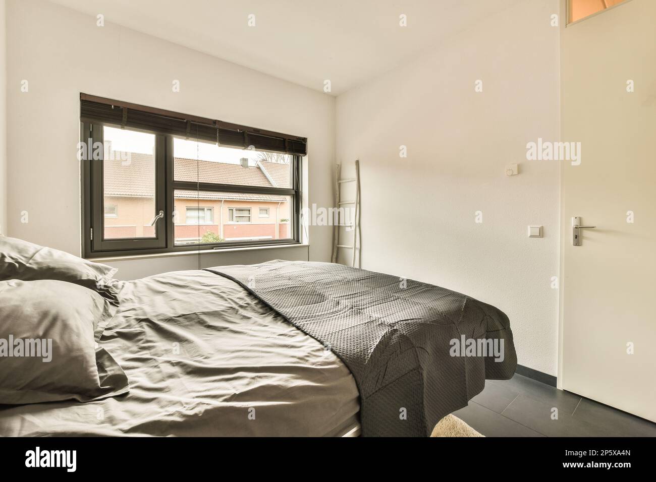 a bedroom with a bed, window, and door to another room in the same ...