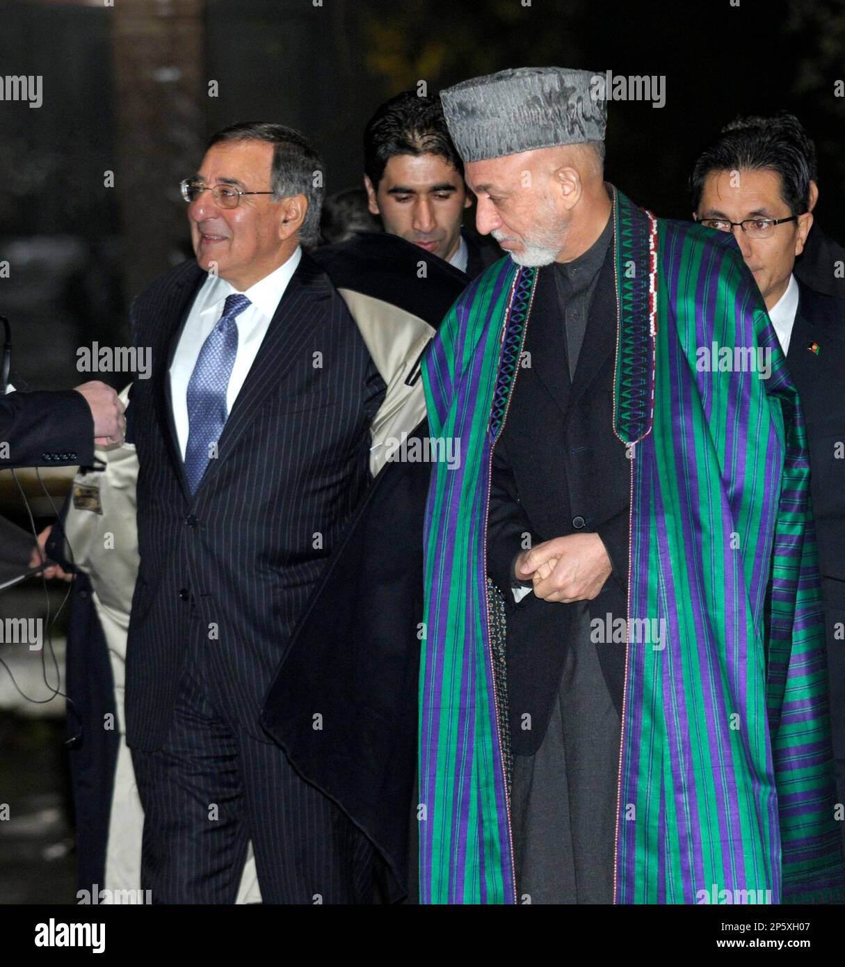U.S. Defense Secretary Leon Panetta, left, takes off his coat as he and ...
