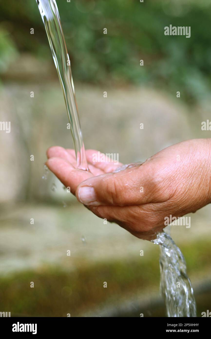 clear water flowing onto the palm of the hand Stock Photo - Alamy