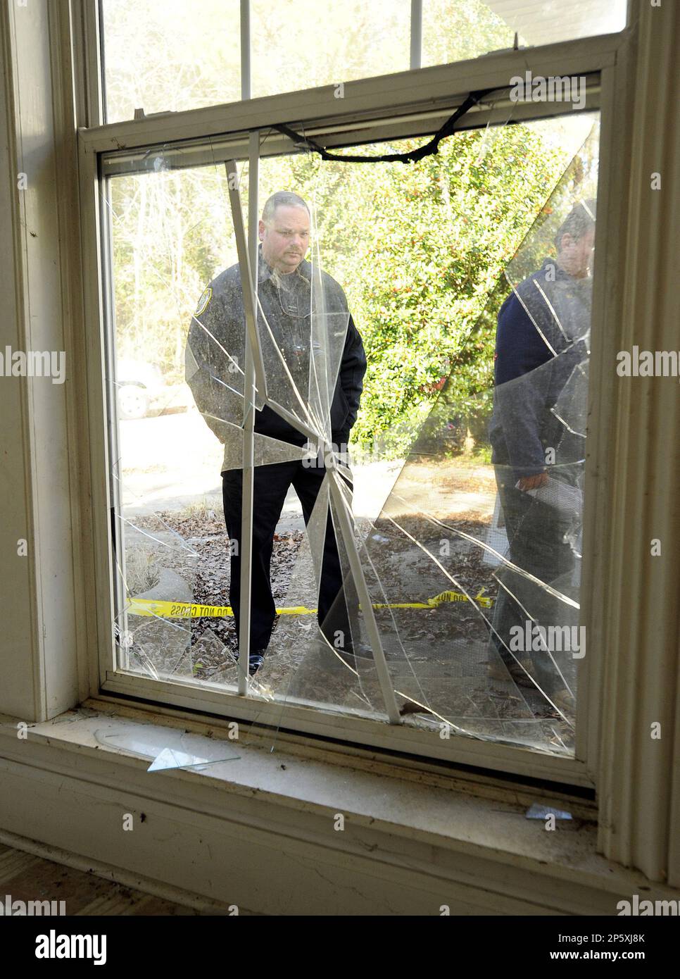 Crime scene unit members examine the broken window during Irondale ...