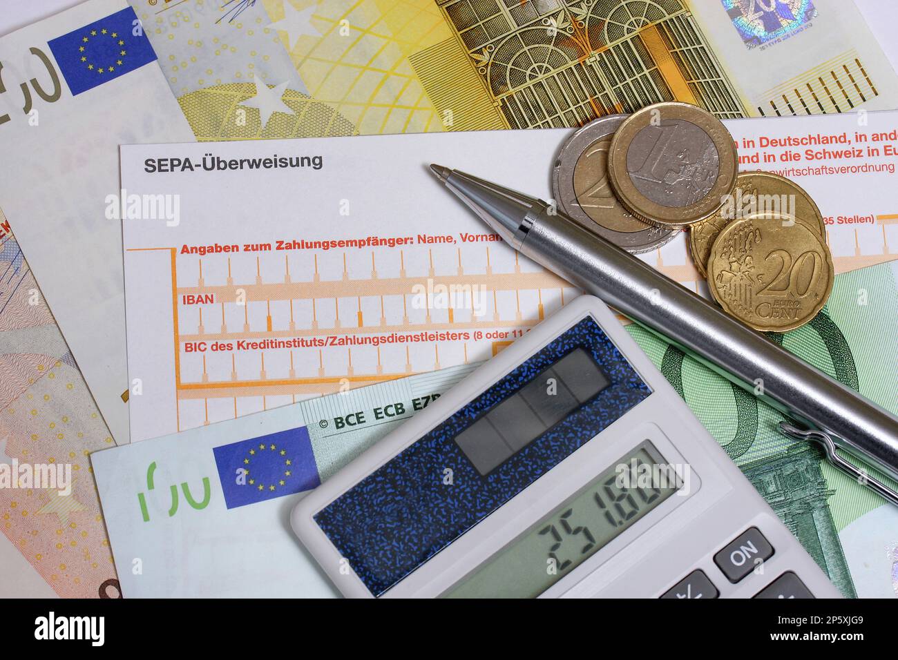 analog SEPA credit transfer and Euro bills and coins, ballpen and ...