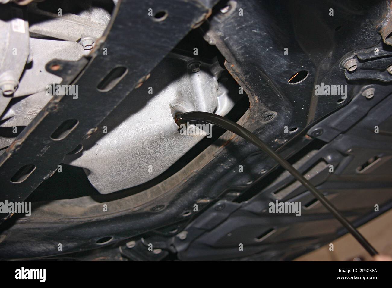 Oil change on the car, waste oil is drained off Stock Photo - Alamy