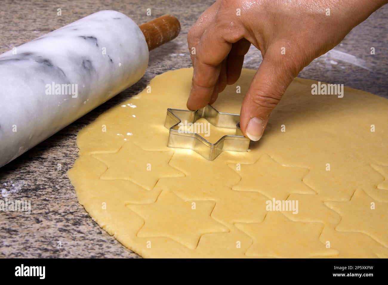 baking Christmas biscuits, star shape is pressed into the dough Stock ...