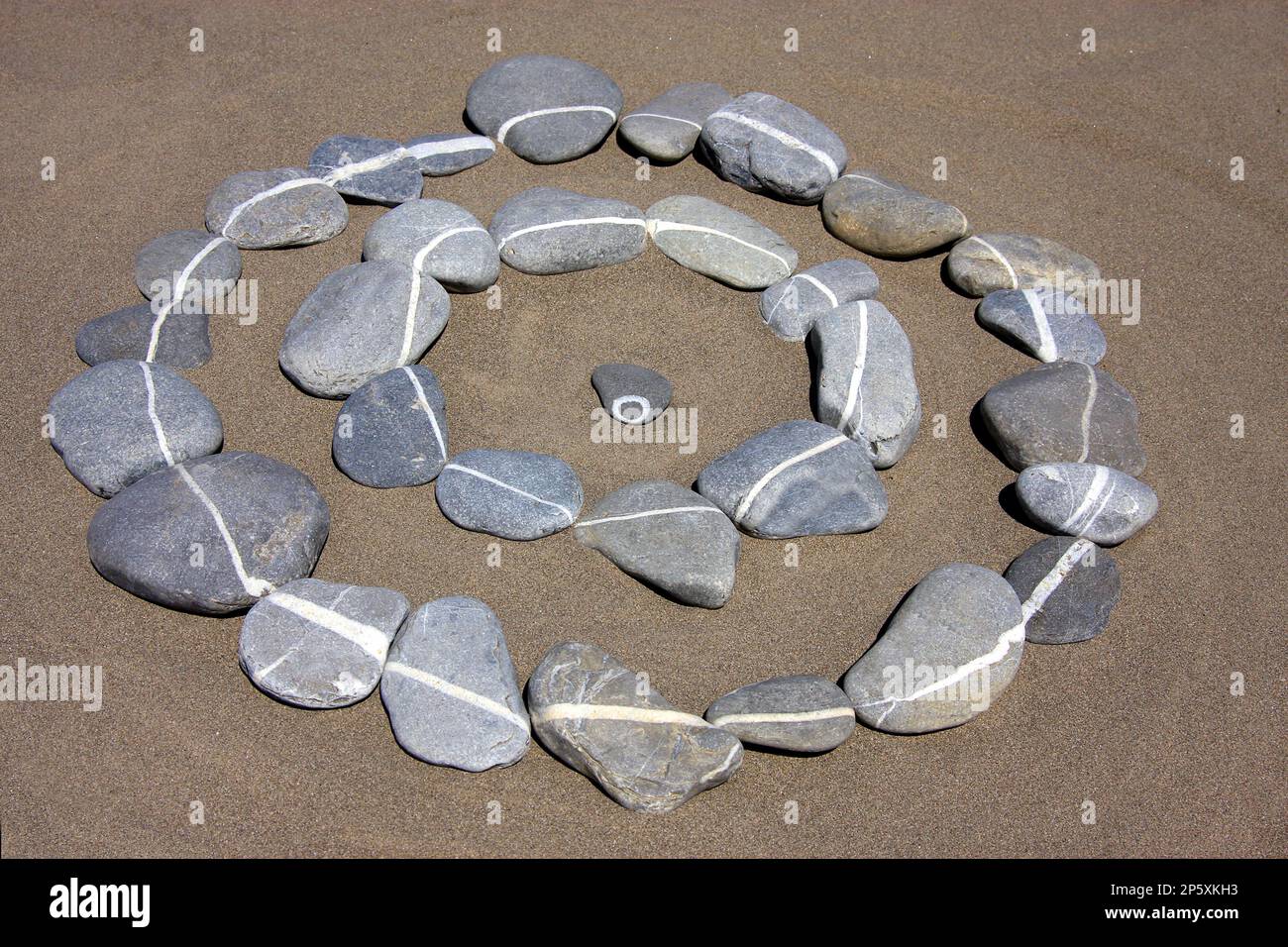 stone circles on sand made of stones with white stripes, little pebble ...