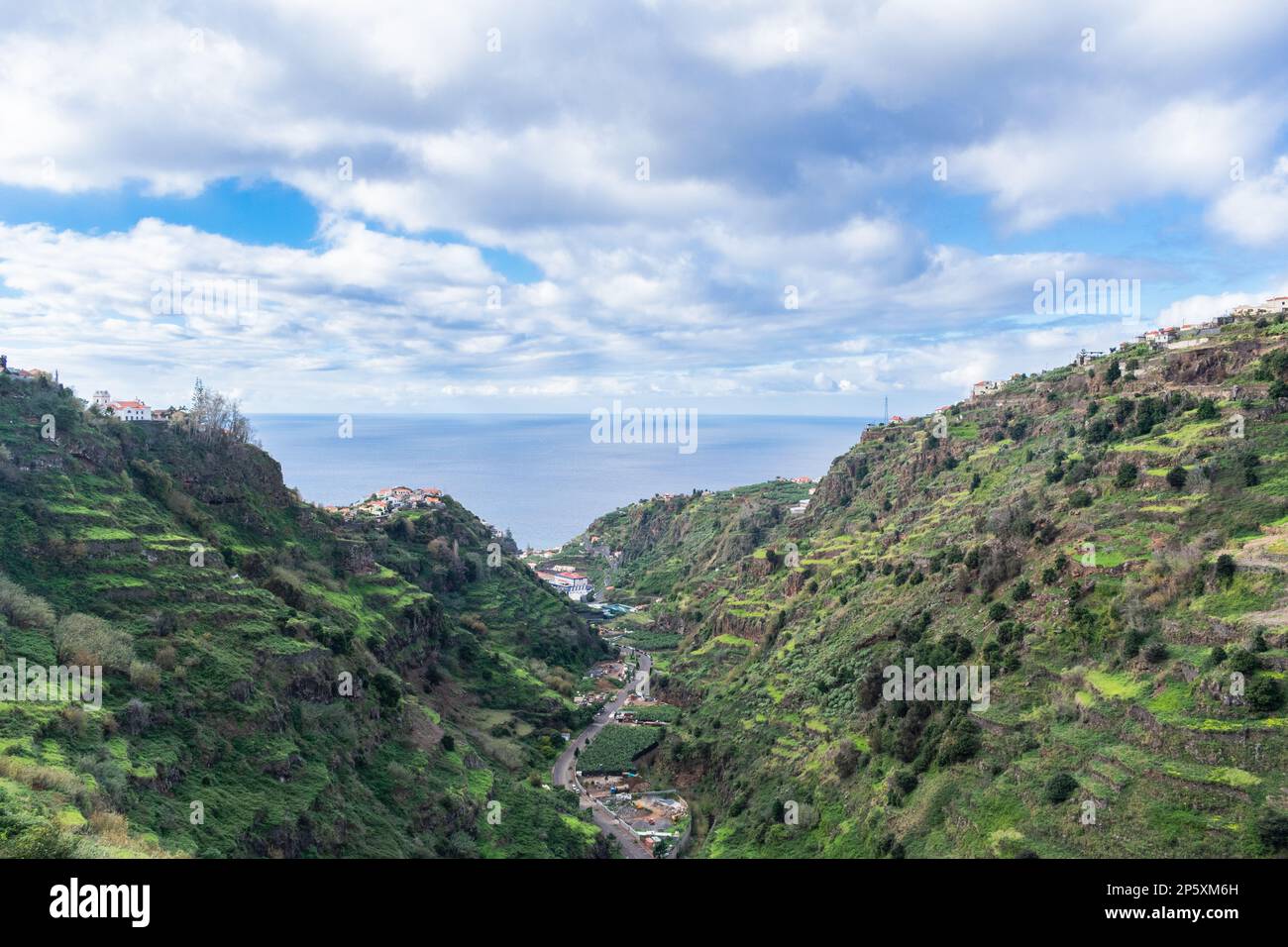 Two mountains with a road in the middle and ocean in the background ...