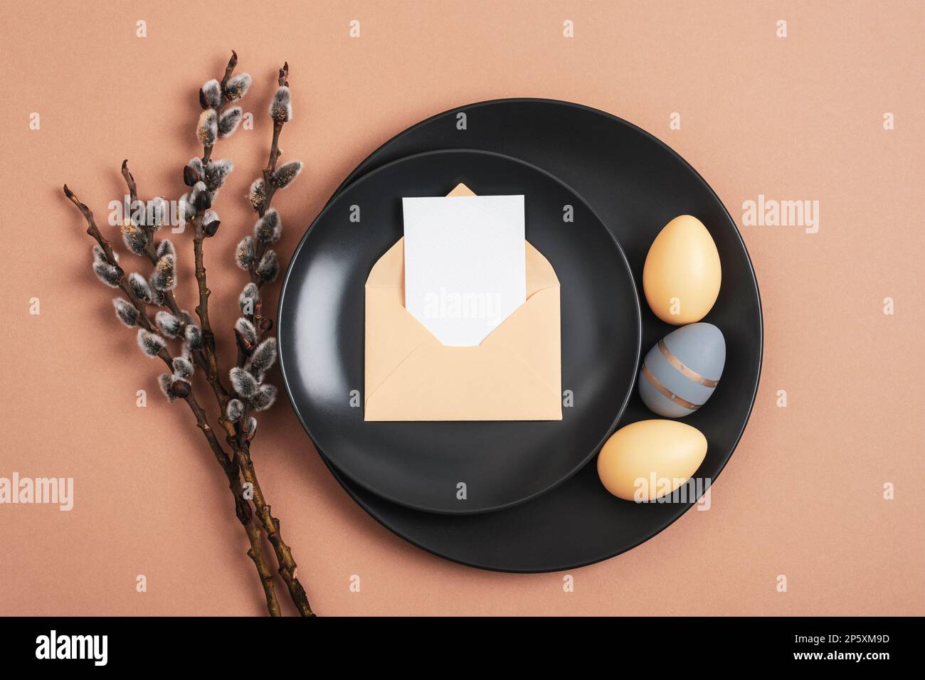 Black plates with painted Easter eggs, envelope with blank card and ...