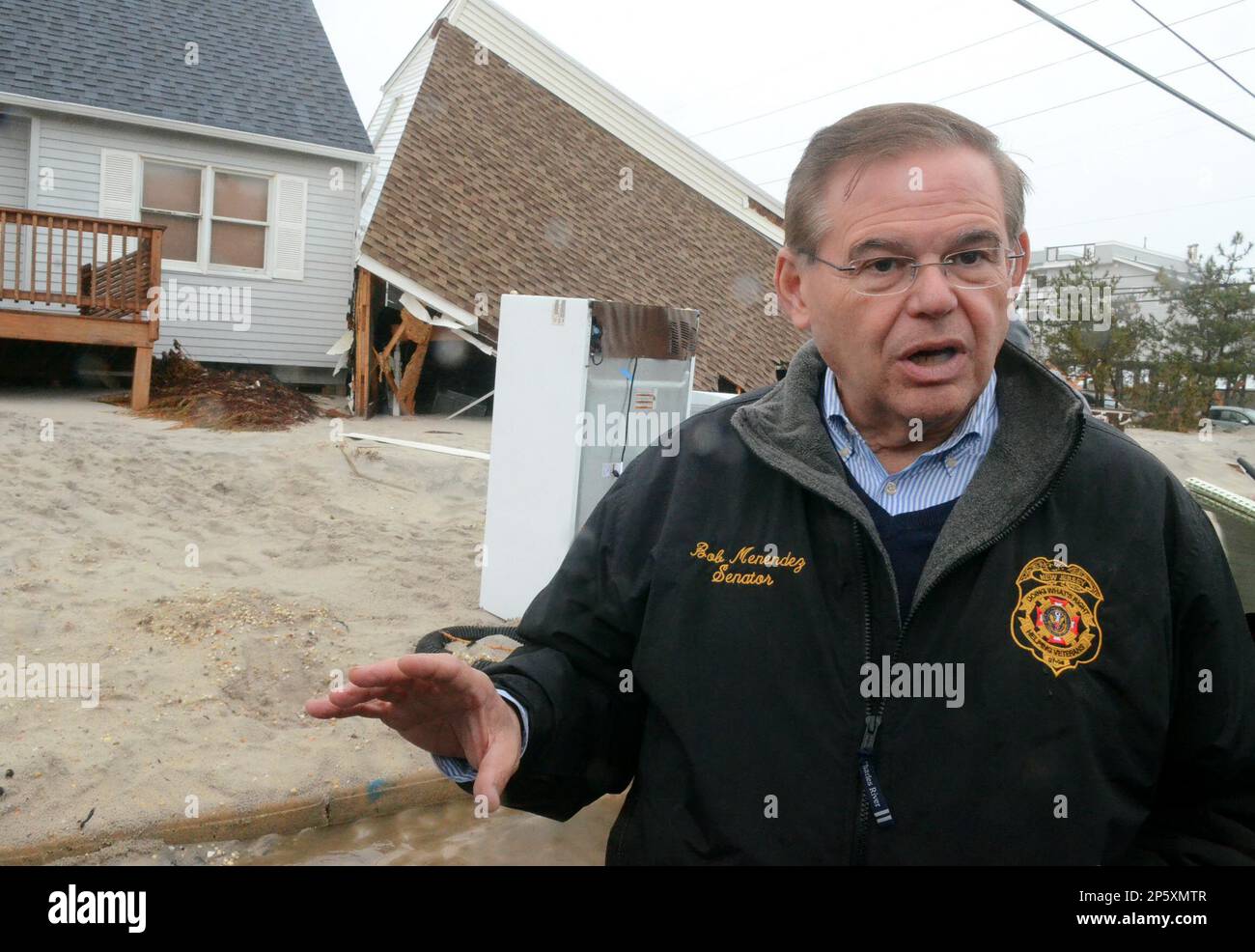 New Jersey Senator Robert Menendez talks in front of a storm damaged ...