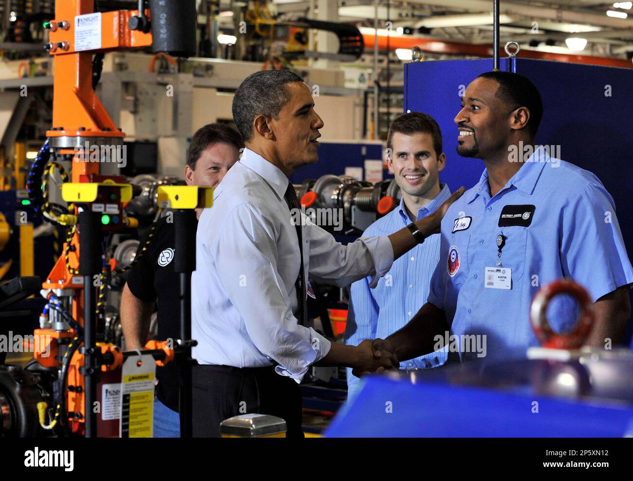 President Barack Obama, left, greets assembler Austin Ivey, right, in ...
