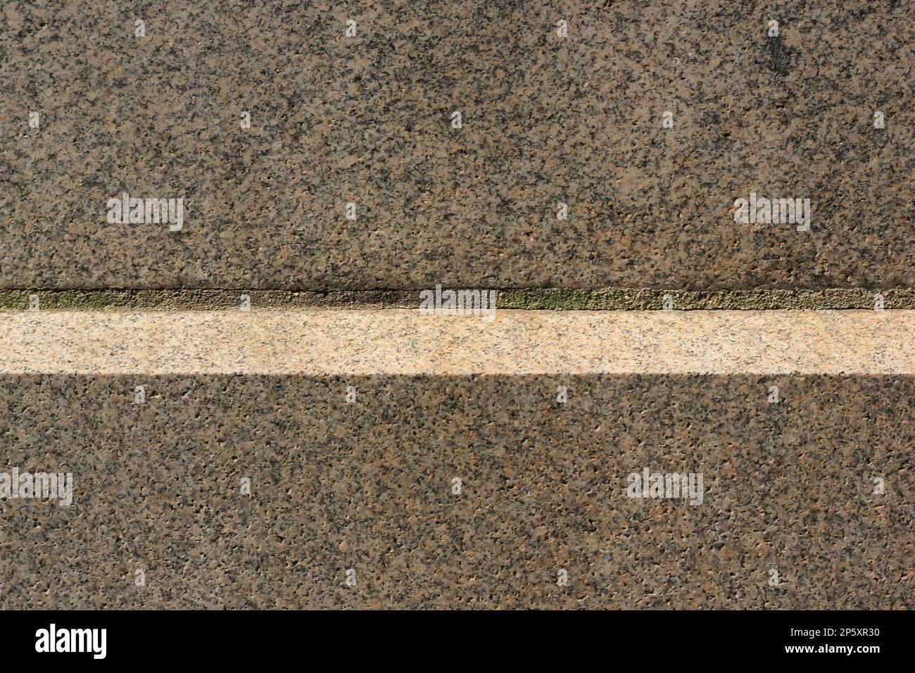 A minimalist view of a natural carved stone wall with a light line ...