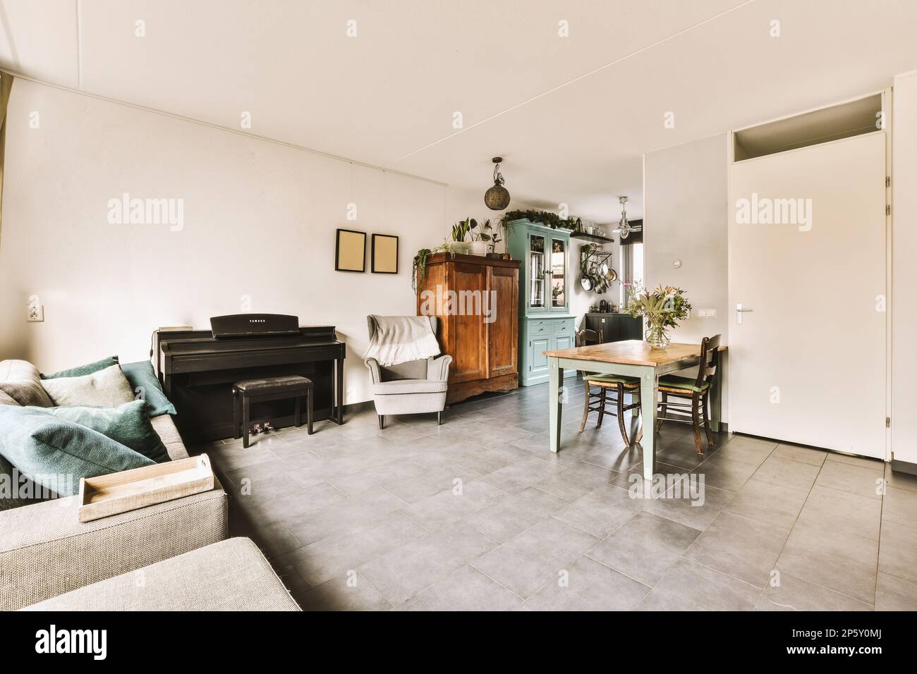 a living room with couches, tables and a piano in the middle of the ...