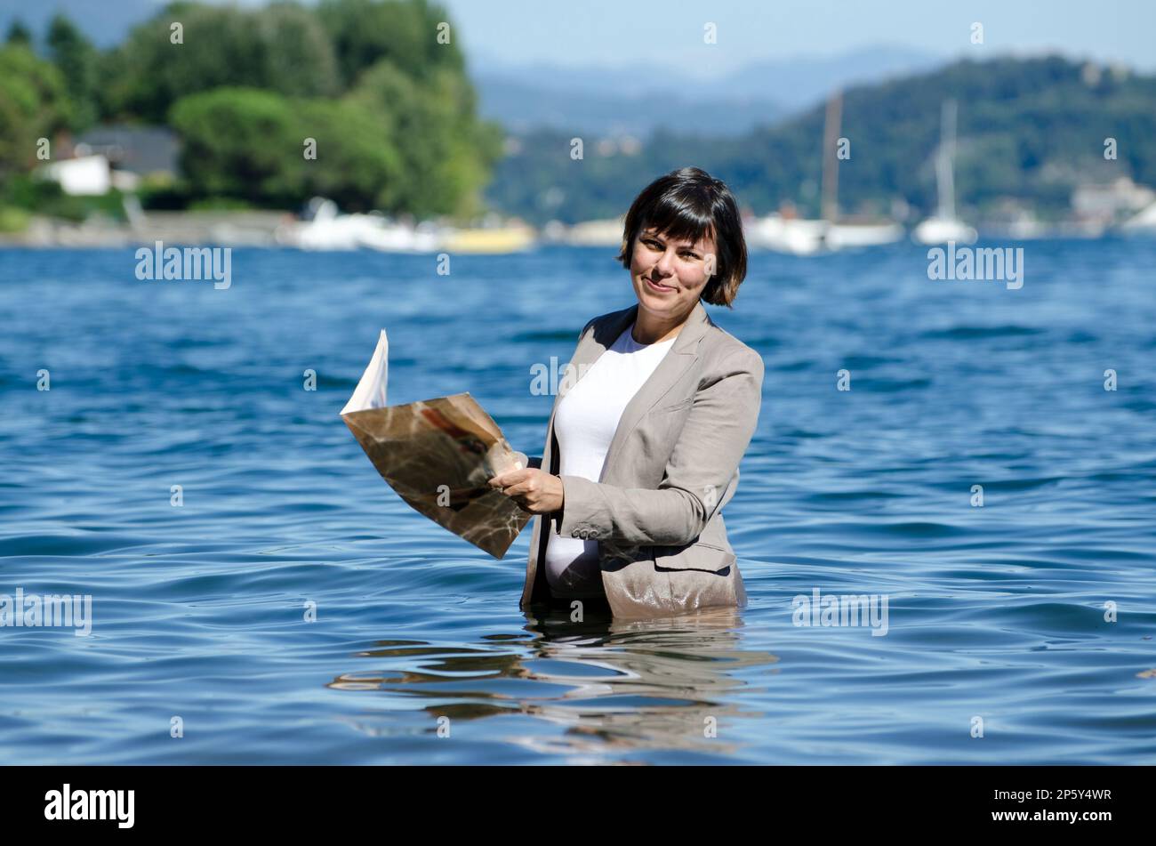 Elegant Business Woman with Suit Standing in the Water and Reading a ...