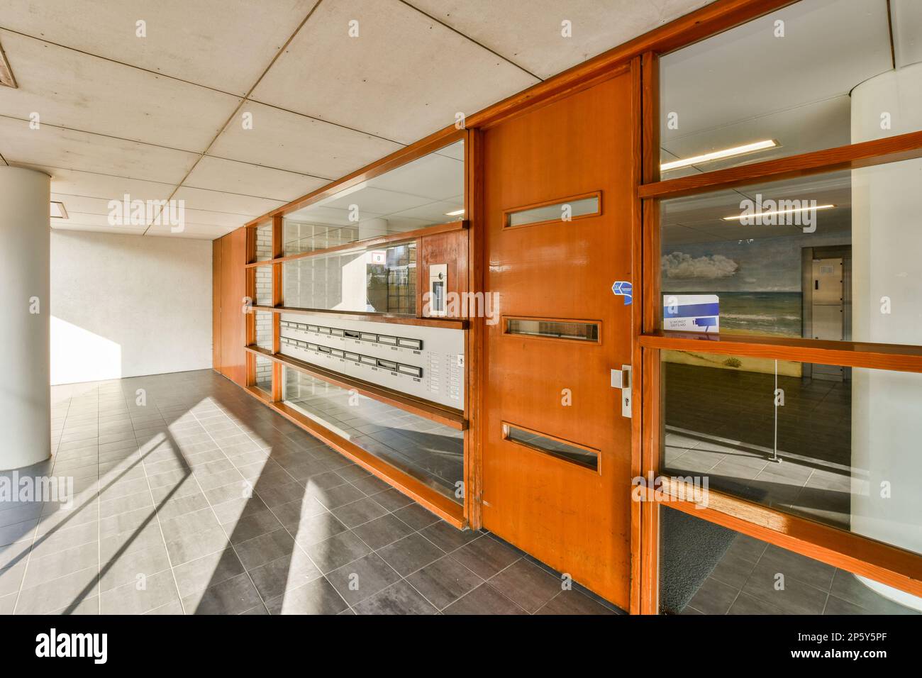 a modern building with wood and glass doors on both sides, in the sun ...