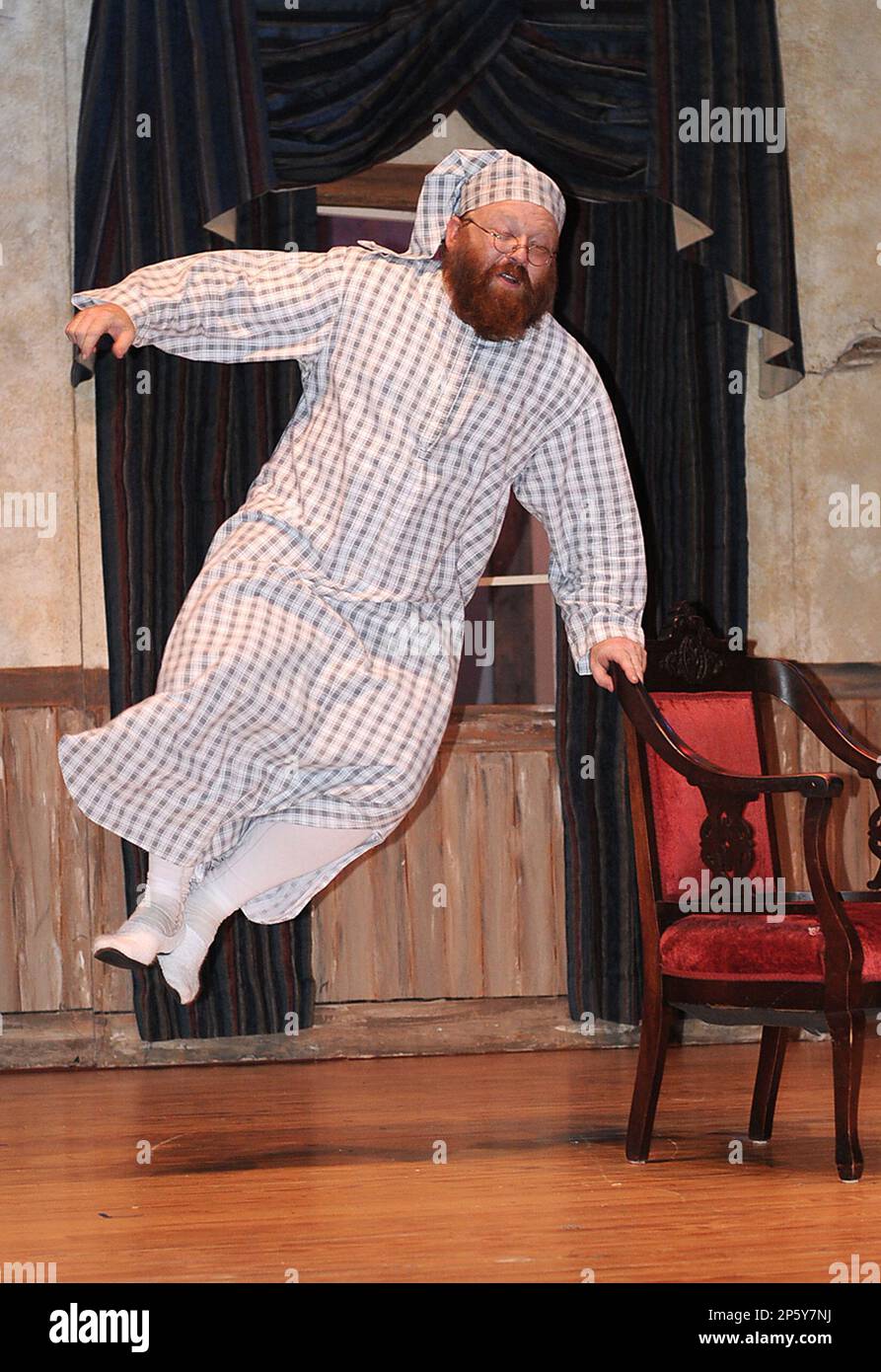 Old miser Ebenezer Scrooge played by William "Bill" Stambaugh jumps ...