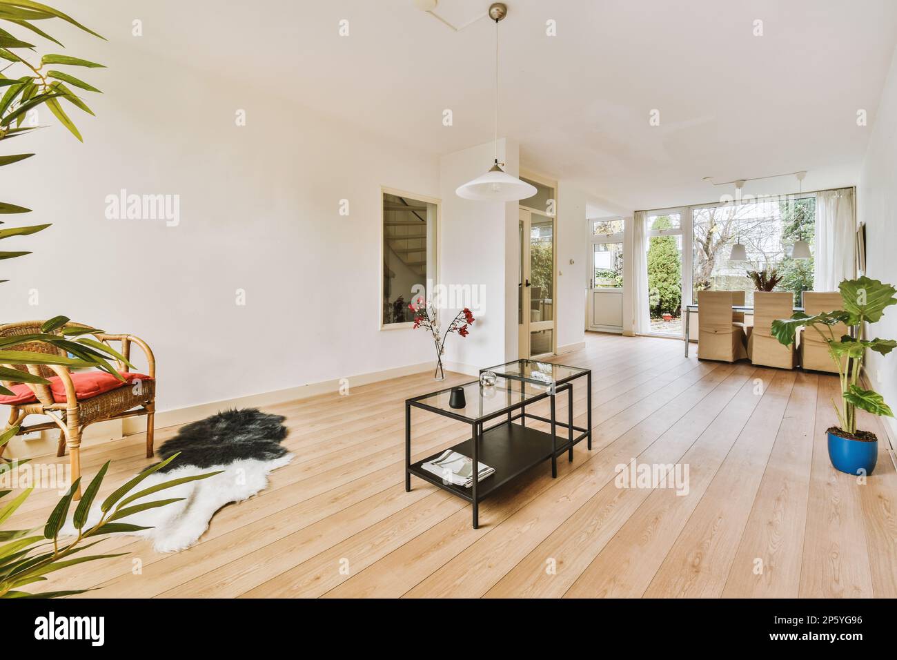 a living room with white walls and wood flooring the room is well lit ...