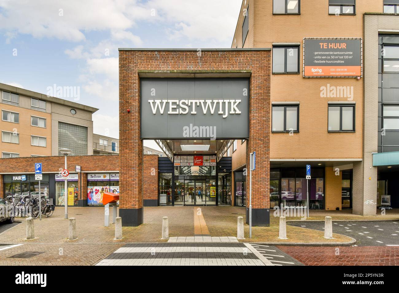 the entrance to westwick shopping centre, with cars parked in front and ...