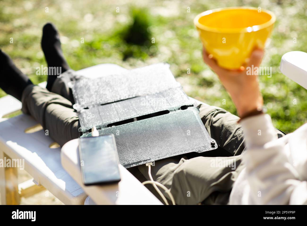 Portable solar battery. Lying on the legs of a resting unrecognizable ...