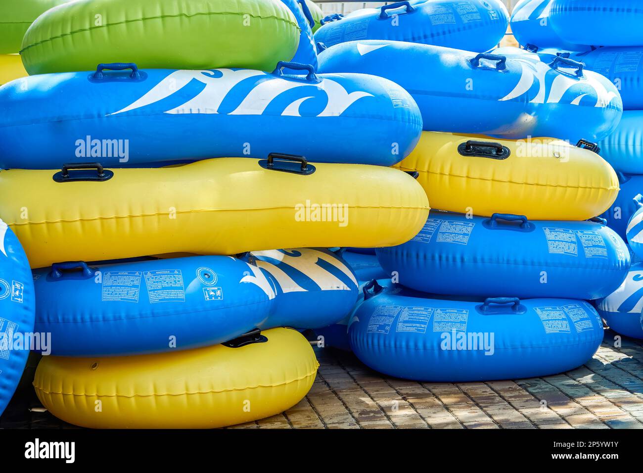 Multi-colored rubber rings for swimming pool put in rows at bright ...