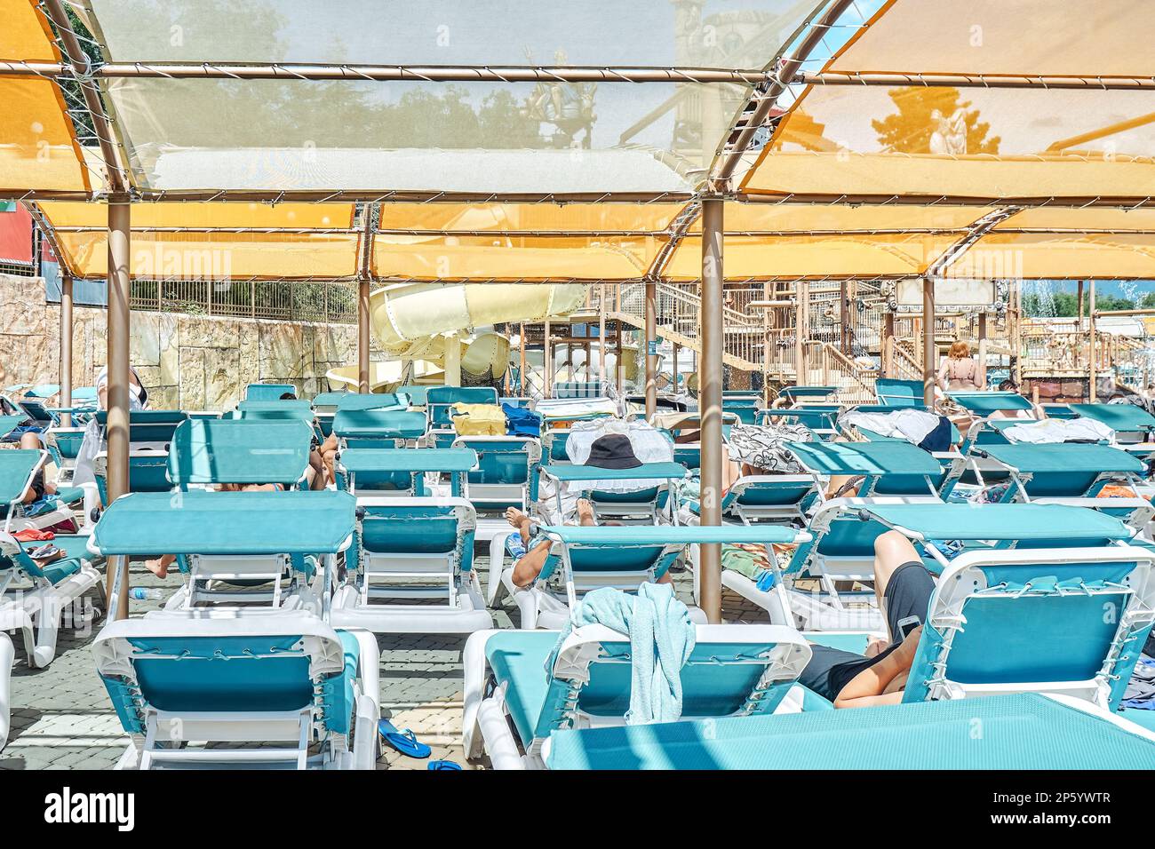 Blue sun loungers put in rows under transparent canopy. Sun-protection ...